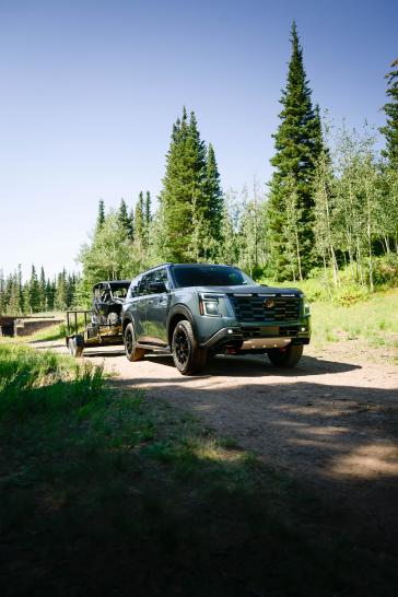 Front right 3/4 view of a green 2025 Nissan Armada on a dirt road ...